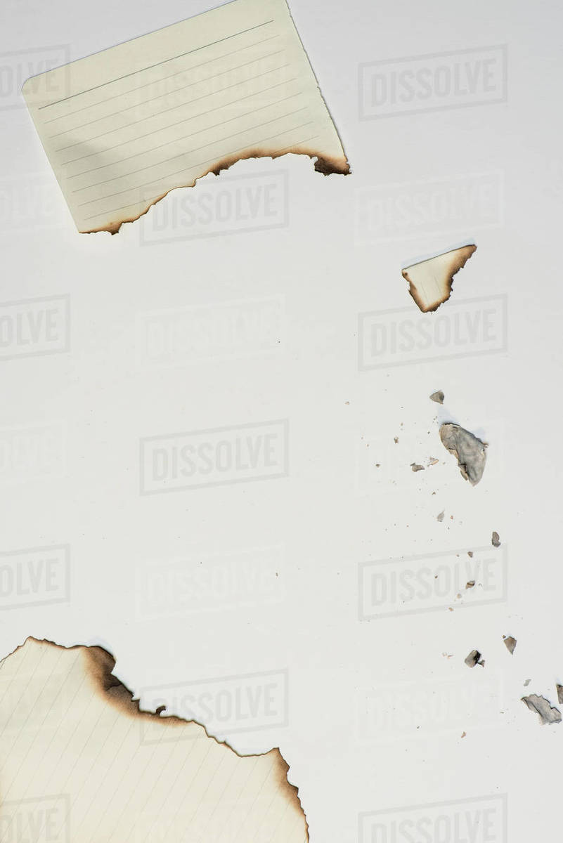top view of pieces of empty writing paper sheet with burned edges ...