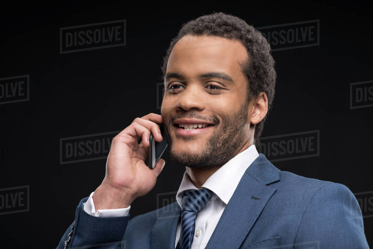 Portrait of successful businessman talking on smartphone isolated on ...