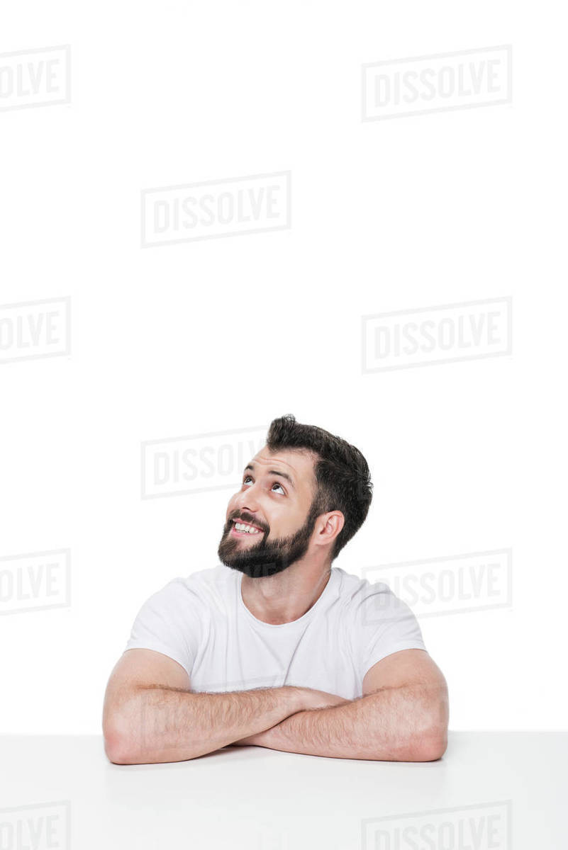Handsome smiling man sitting at table and looking away isolated on ...