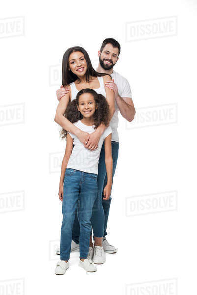 Smiling multiethnic family standing and looking at camera together ...