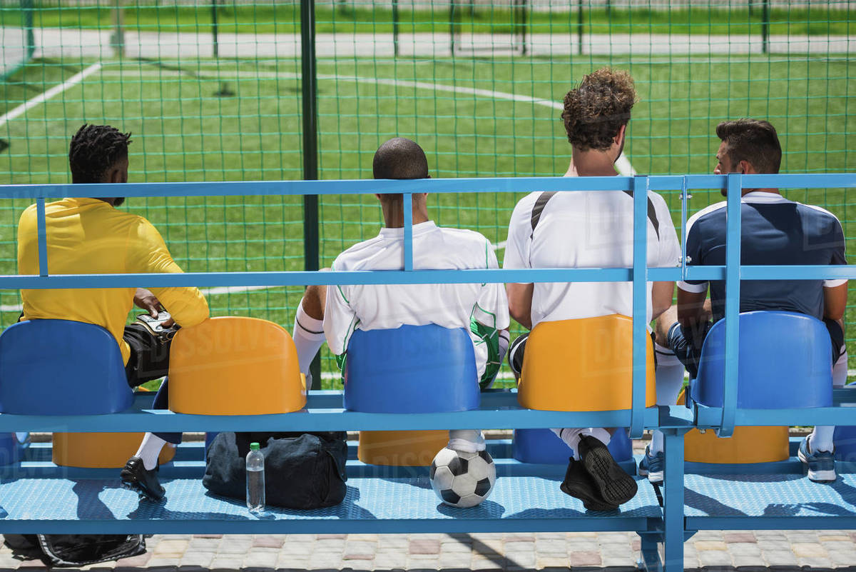 Multicultural soccer team resting on stadium before soccer match ...