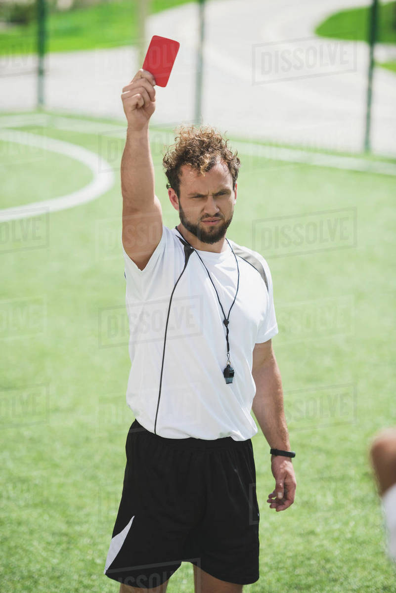 Soccer referee showing red card during soccer match on pitch - Royalty ...