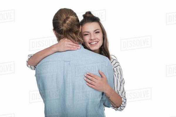 Back view of young man hugging beautiful girl smiling at camera ...