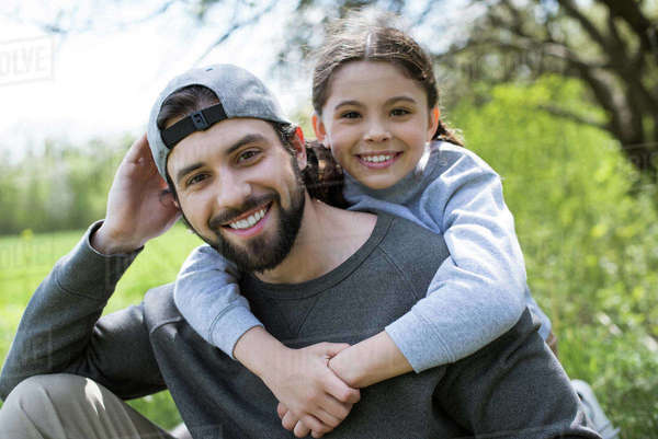 Little child embracing smiling father in park - Stock Photo - Dissolve