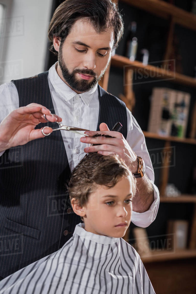 Curly little kid getting haircut at kids barbershop - Royalty-free ...
