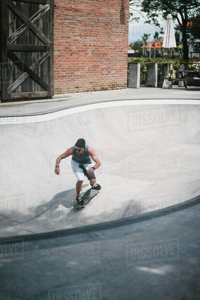 Handsome skater skating in pool in skatepark in Bali, Indonesia ...