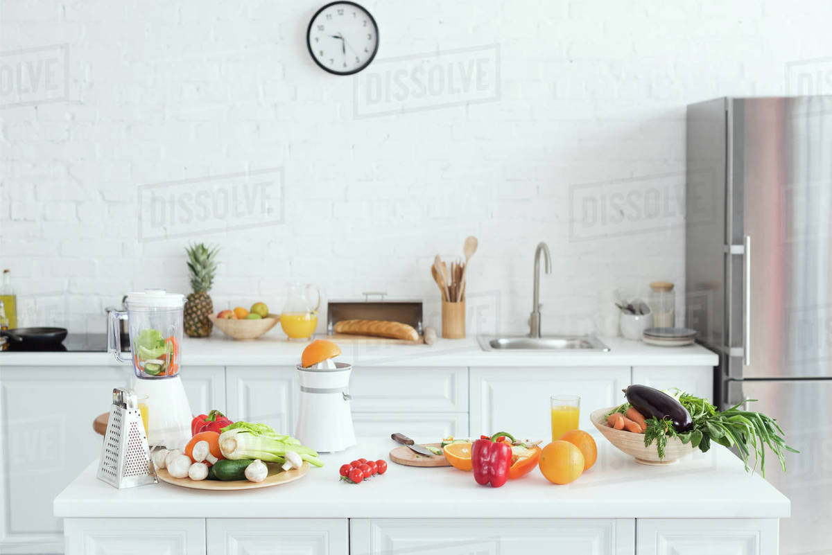 Interior of white light kitchen with delicious fruits and vegetables on ...
