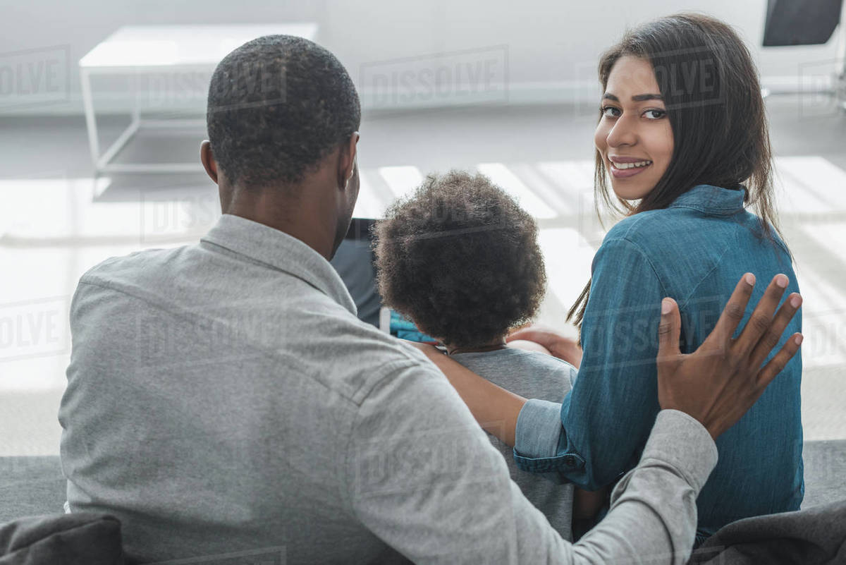 Back view of African american parents and son watching something at ...