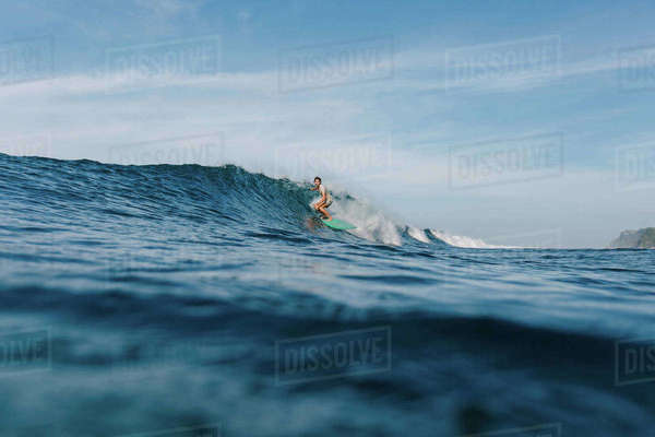 Handsome man riding waves on surfboard on sunny day - Royalty-free ...