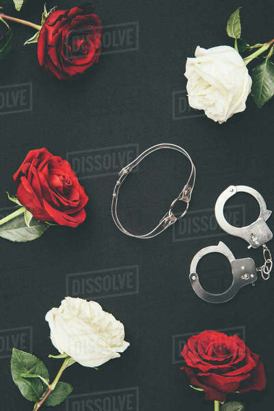 Collar and handcuffs with rose flowers isolated on black - Royalty-free ...