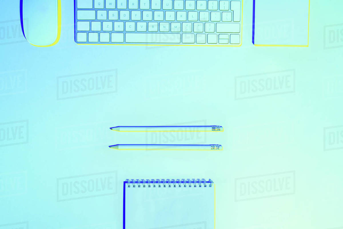 blue toned picture of computer keyboard and mouse, pencils and empty ...