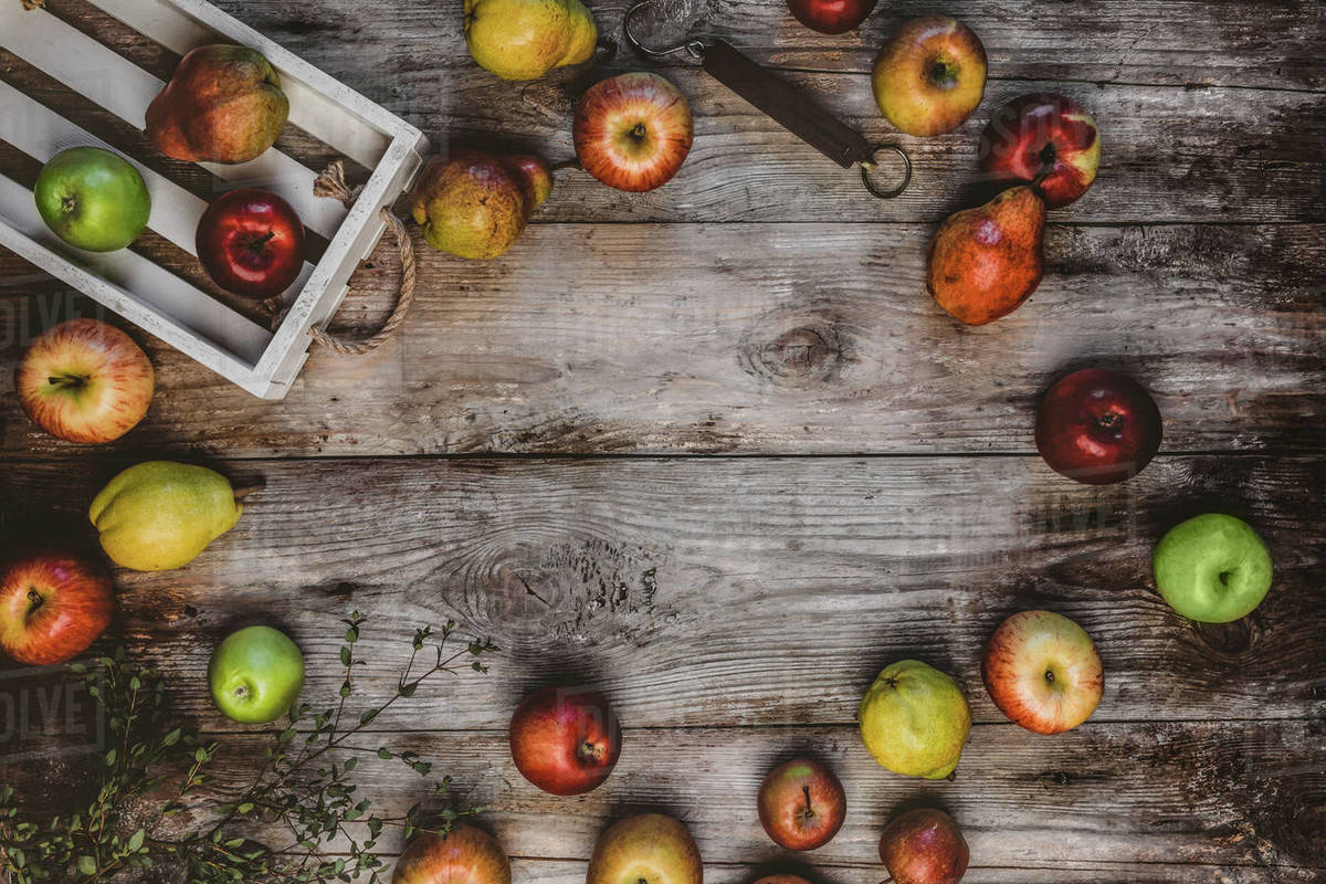 top view of wooden box, hand scales, apples and pears on rustic table ...