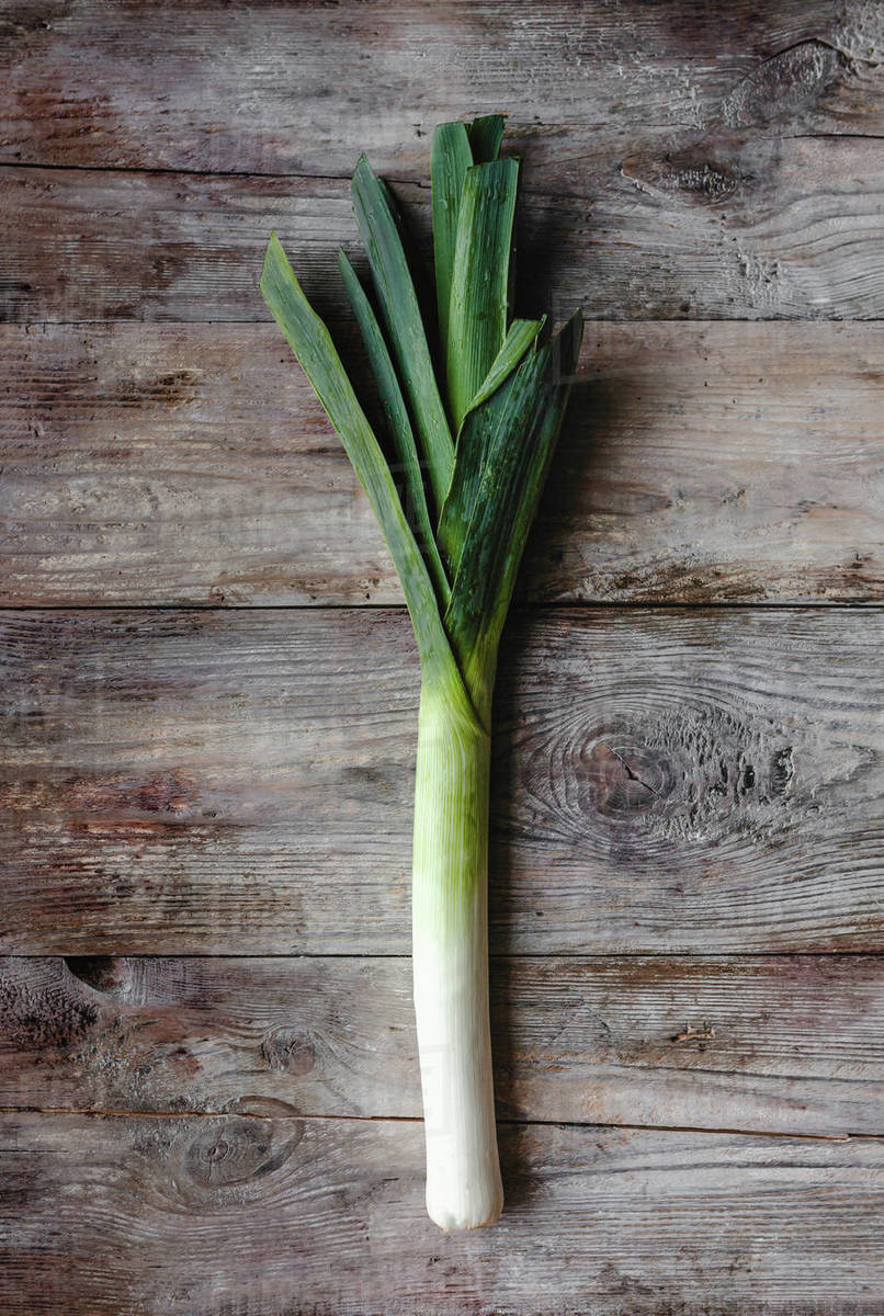 top view of leek on rustic wooden table - Stock Photo - Dissolve