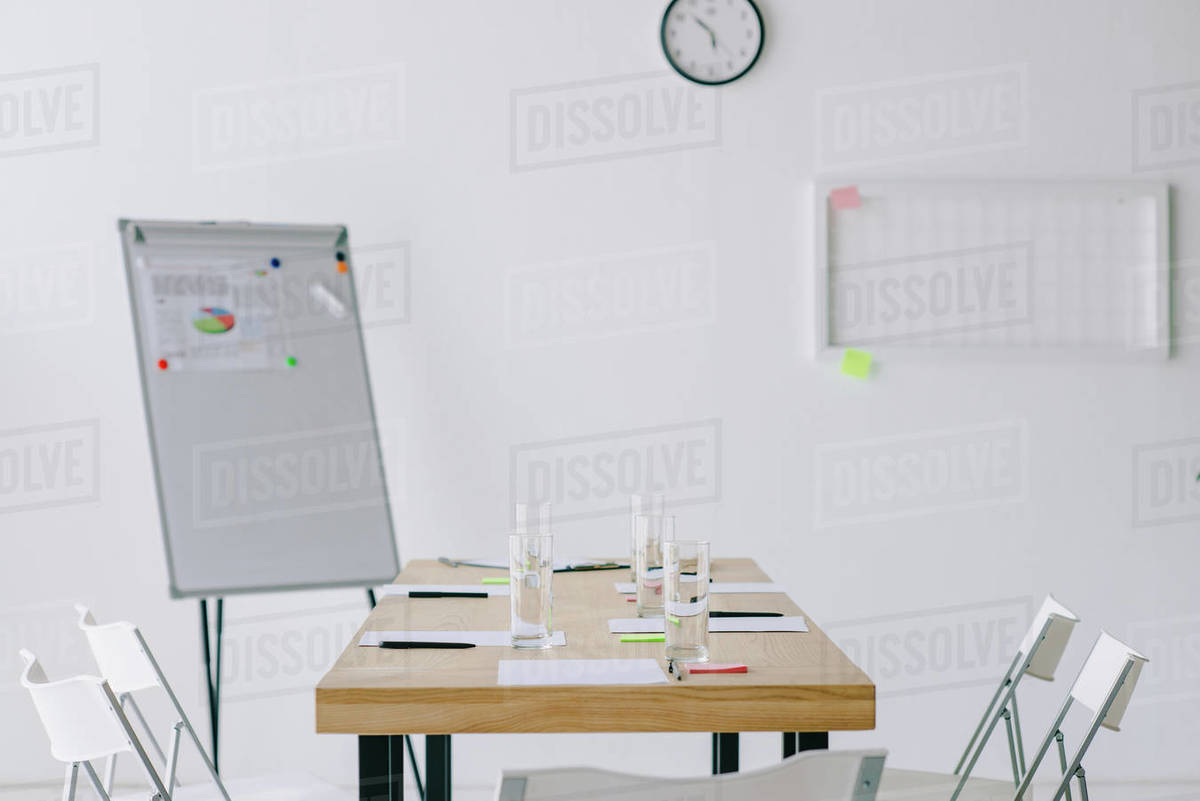 Selective focus of white board with graphic, glasses of water and ...