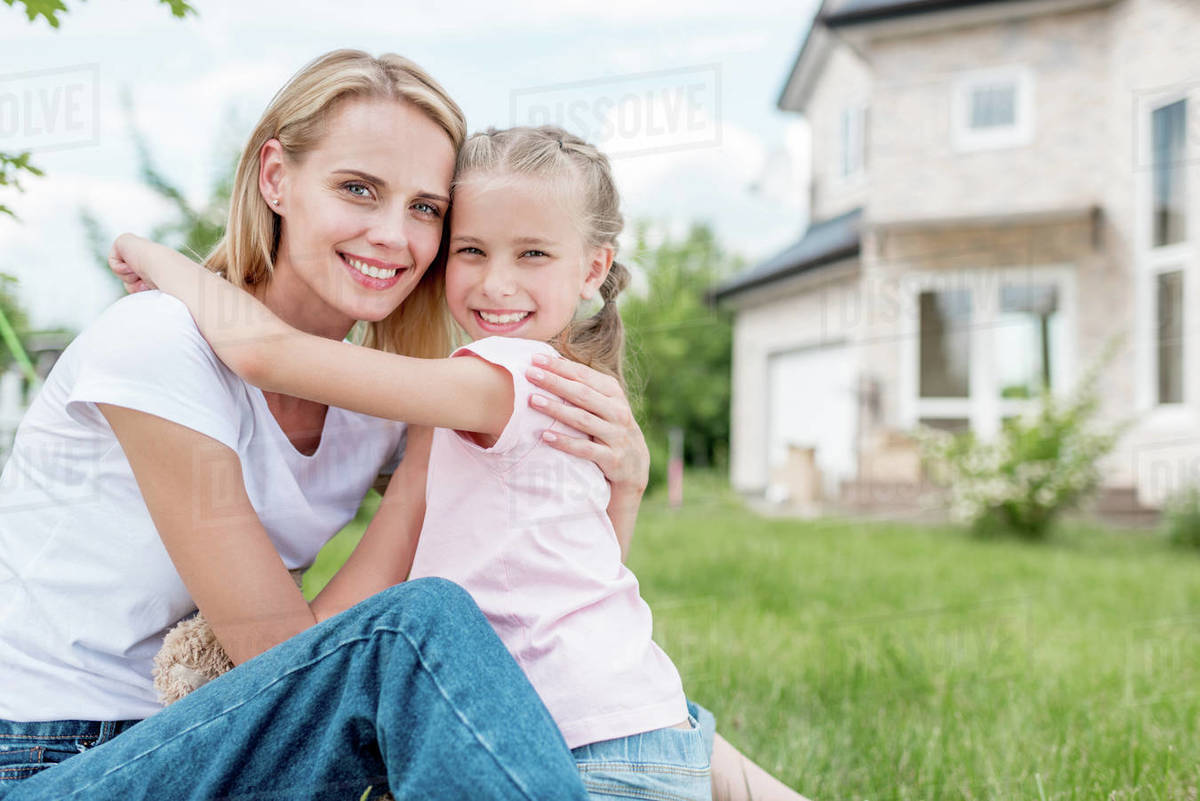 Happy little child embracing smiling mother on green lawn - Stock Photo ...