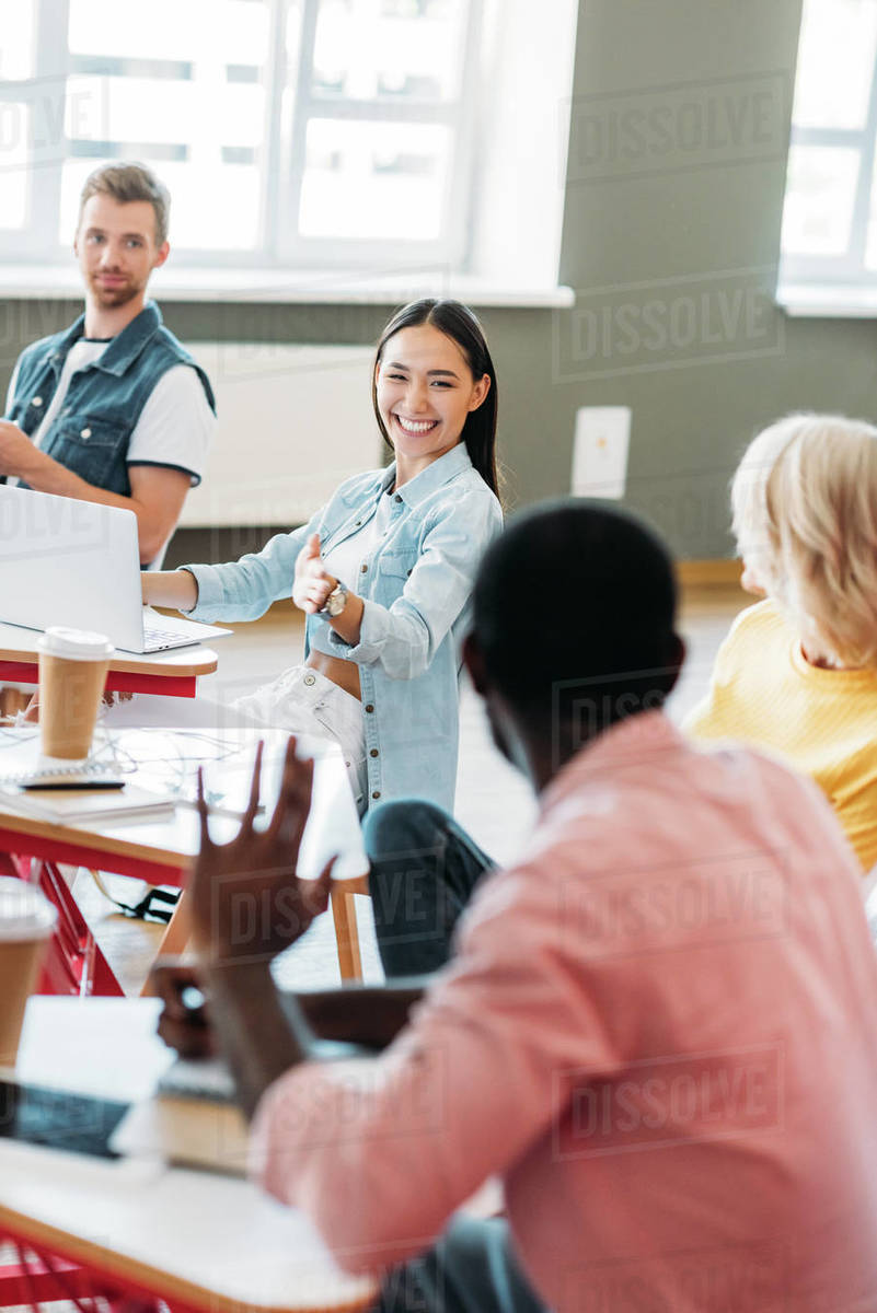 Happy young students chatting at classroom of college - Royalty-free ...