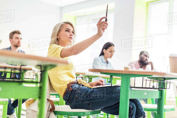 Concentrated young students sitting in classroom during lesson ...
