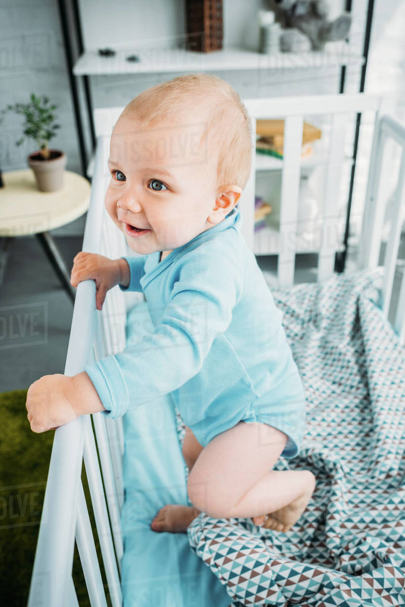 High angle view of happy little baby standing in crib - Royalty-free ...