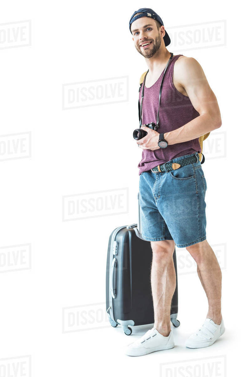 Happy male tourist with travel bag and camera ready for trip, isolated ...