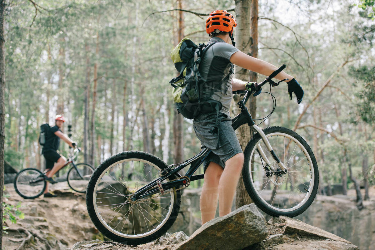 Selective focus of male extreme cyclist on mountain bike talking to ...
