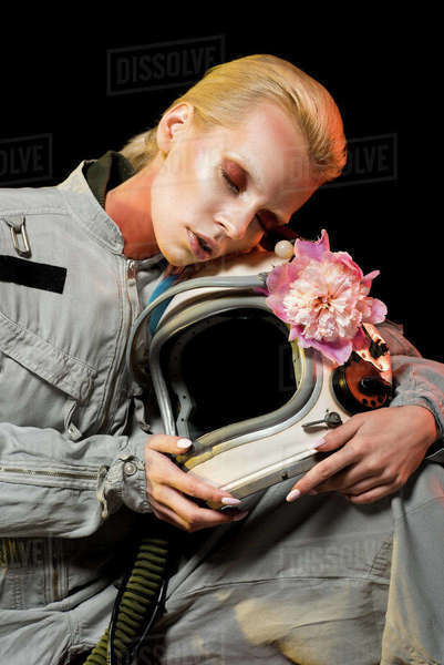 Sensual female astronaut in spacesuit with peony flower and helmet ...
