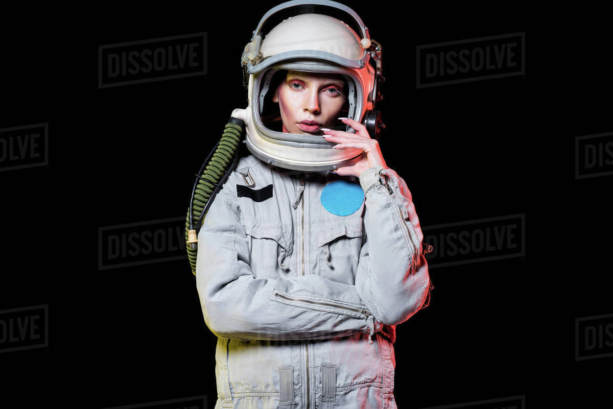 Attractive female astronaut in spacesuit and helmet isolated on black ...
