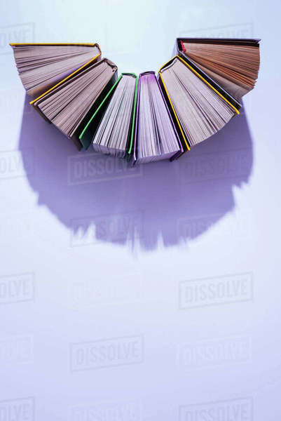 Top view of stack of books in half circle on violet table - Royalty ...