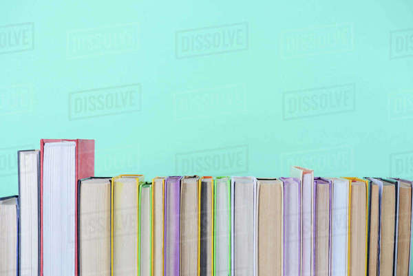 Row of different colored books isolated on blue - Royalty-free Stock ...