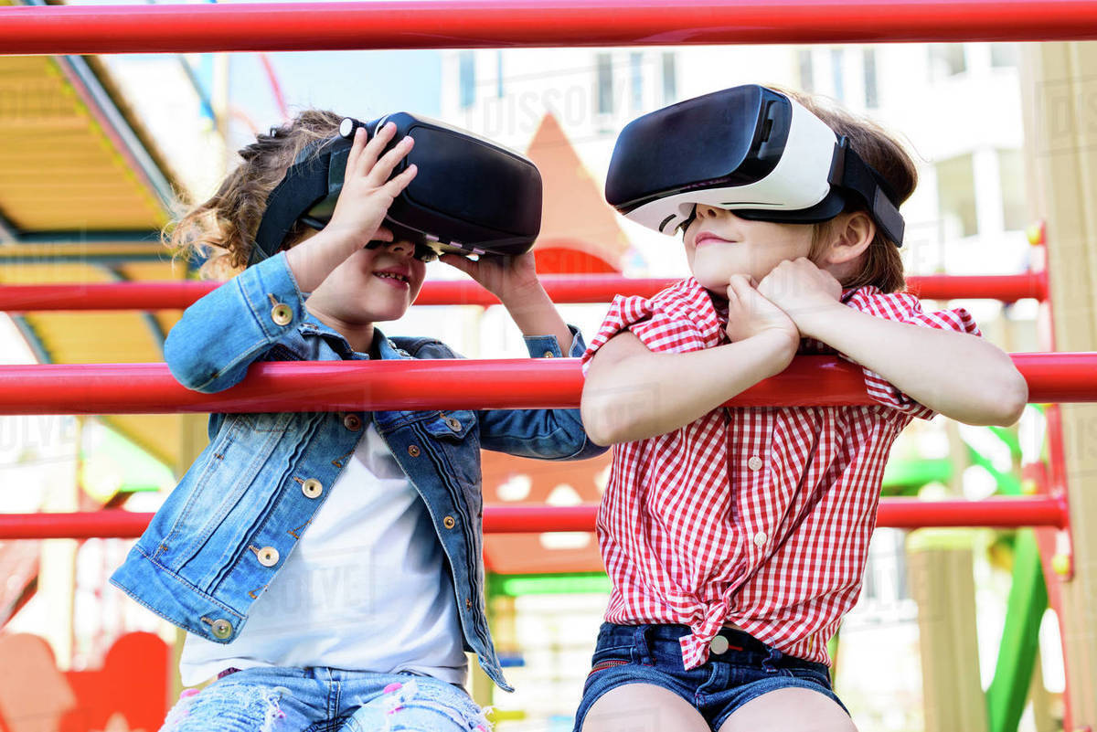 Selective view of two little children using virtual reality headsets at ...