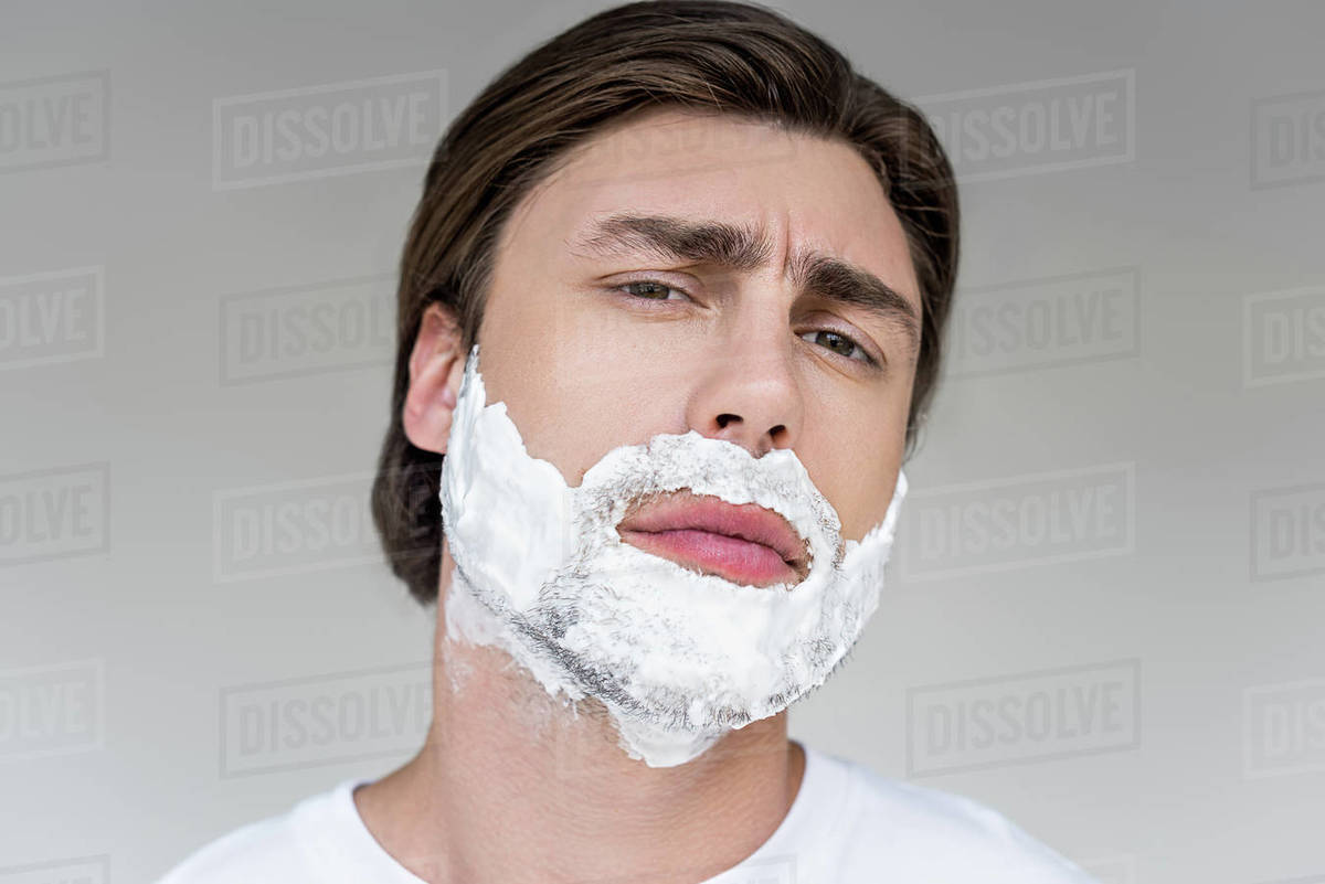 portrait of handsome man with shaving foam on face looking at camera isolated on grey - Royalty ...
