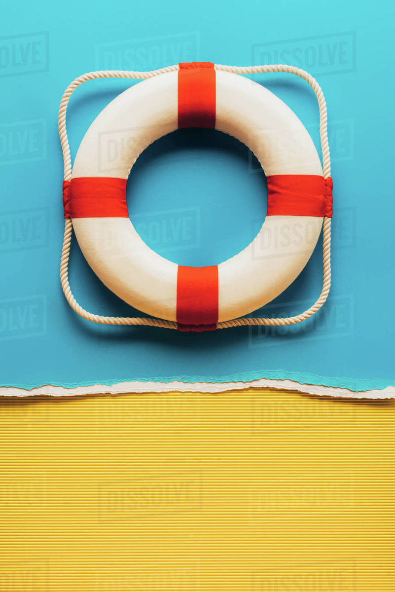 top view of red and white life saver on blue and yellow paper ...