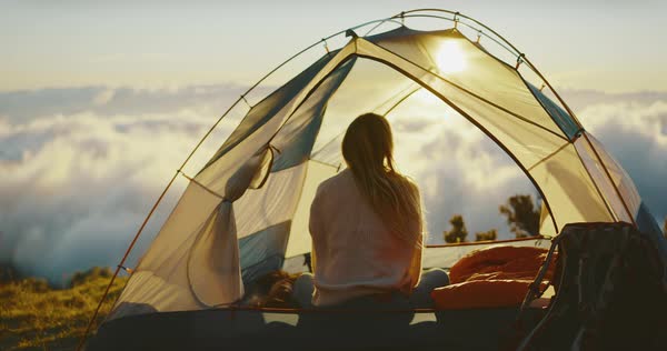 Camping at sunset, beautiful woman relaxing in tent above the the ...