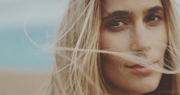 Portrait of a beautiful woman with wind blowing through her hair in ...