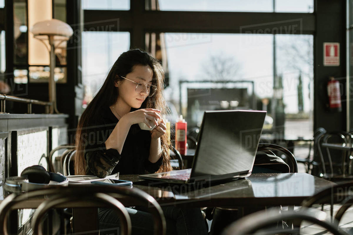 Asian woman working on a laptop in coffee shop - Royalty-free Stock ...
