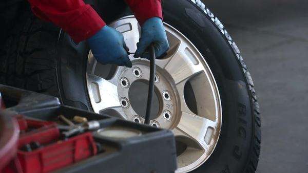Mechanic fixes tire and installs a new tire on a car wheel rim using ...