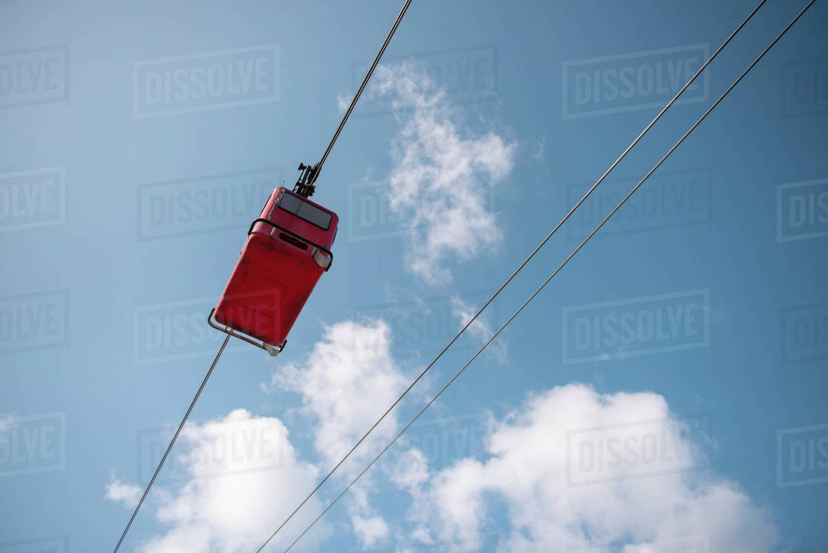 Overhead cable cars against blue sky - Stock Photo - Dissolve