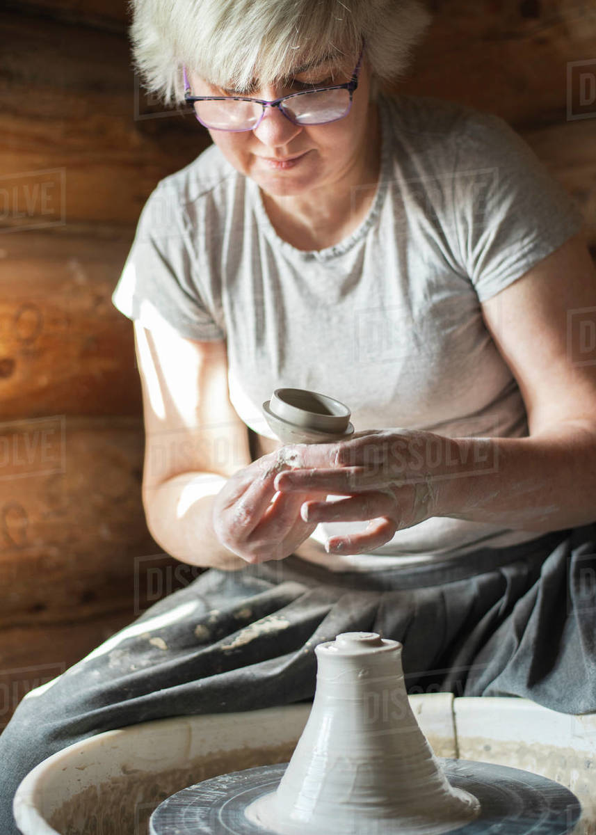 Female potter working with a pottery wheel in her workshop - Stock ...