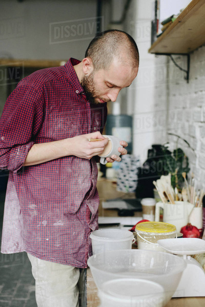 Male maker ceramics working with clay and creating a shape of ceramic ...