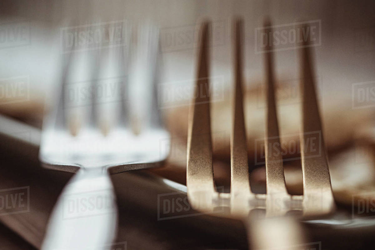 Close-up of two forks leaning on the edge of a plate - Royalty-free ...