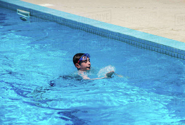 Boy swimming in a swimming pool - Stock Photo - Dissolve