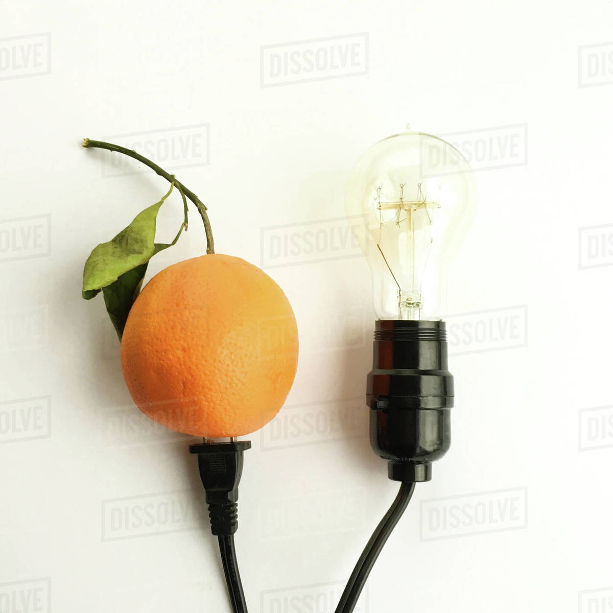 Light bulb plugged into an orange to illustrate Food generating clean ...