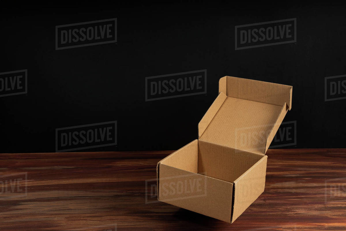 Close-up of an empty open cardboard box on a wooden table - Royalty ...