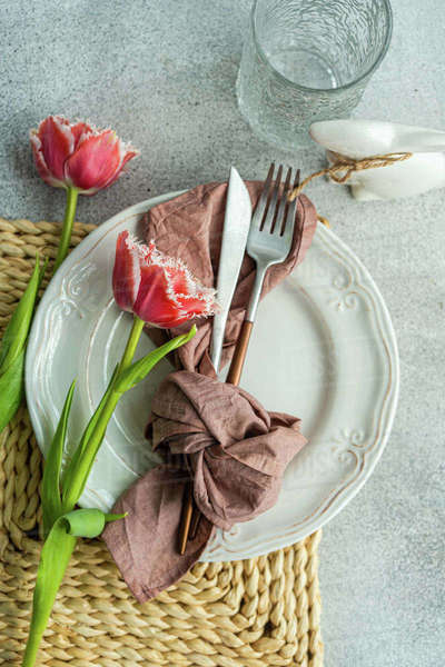 Close-up overhead view of a Spring place setting with pink tulips ...