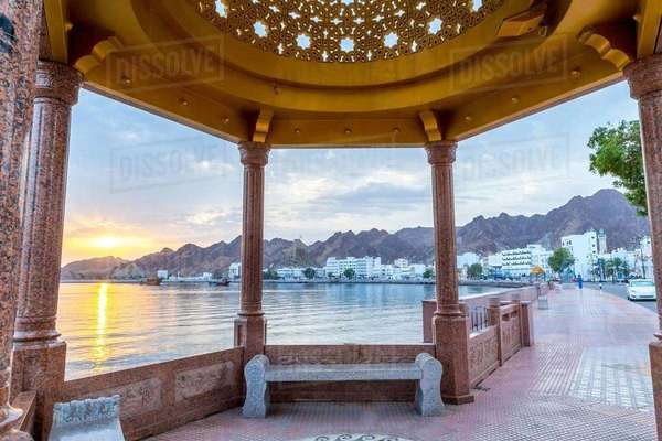Buildings along waterfront Promenade with mountain backdrop at sunrise ...