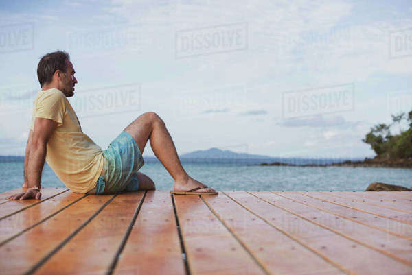 Man sitting on pier looking at sea, Thailand - Royalty-free Stock Photo ...