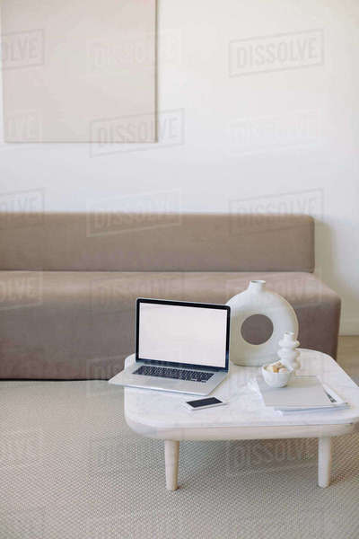 Open laptop computer with a blank screen on a coffee table in a living ...
