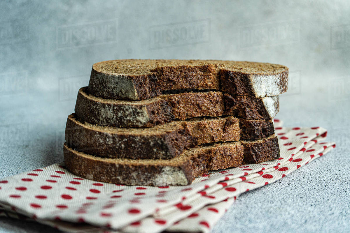 Stack of dark sourdough rye bread slices on a folded napkin - Royalty ...