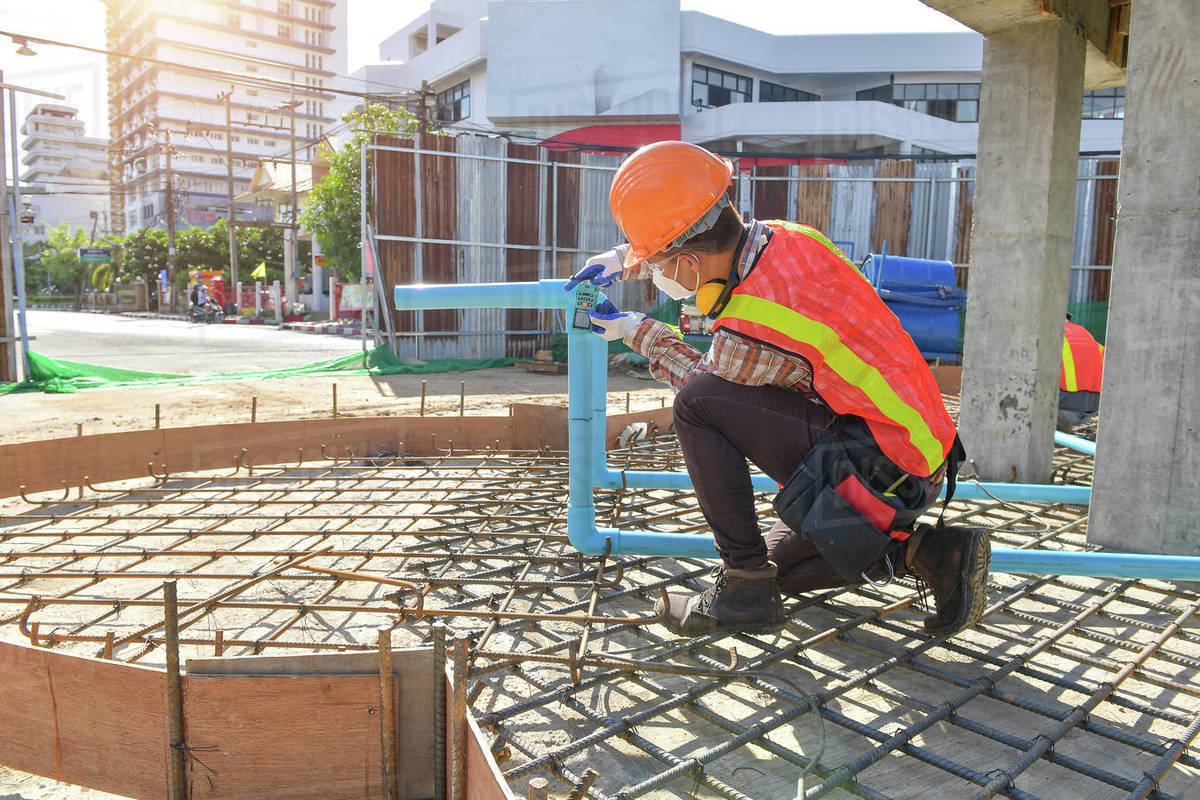 Construction worker using a Laser measuring tool on a construction site ...