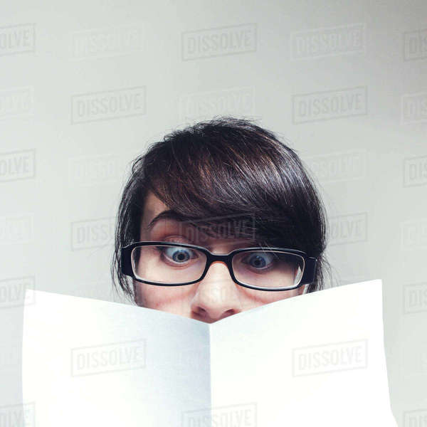 Teenage girl staring at sheet of paper - Stock Photo - Dissolve