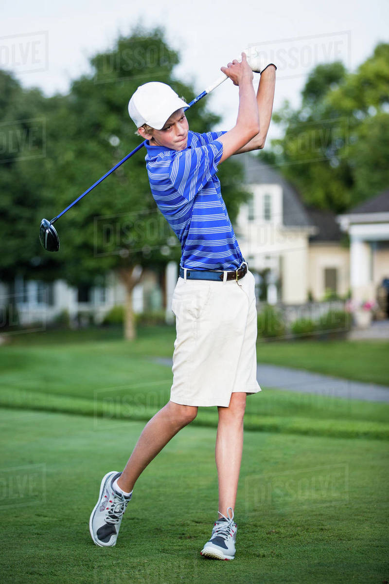 Teenage boy playing golf - Stock Photo - Dissolve